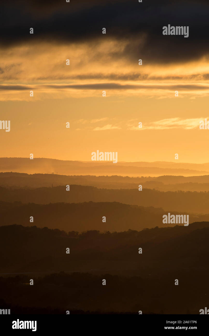 Layers of mountains fade into the distance in the glowing sunrise ...