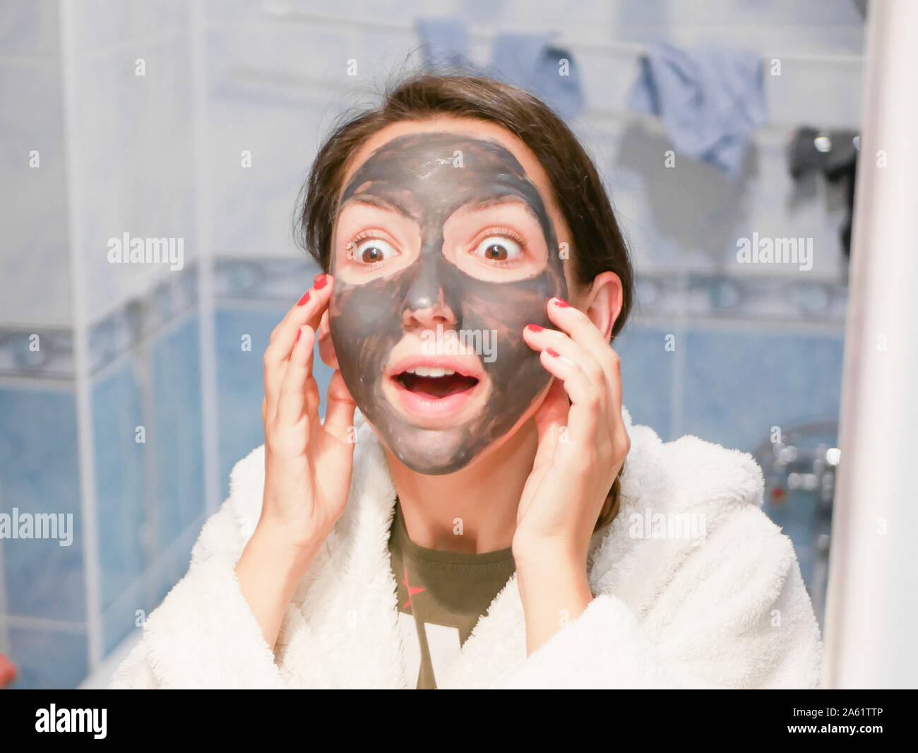 surprised girl in a mask near the mirror. skin care. amazing result ...