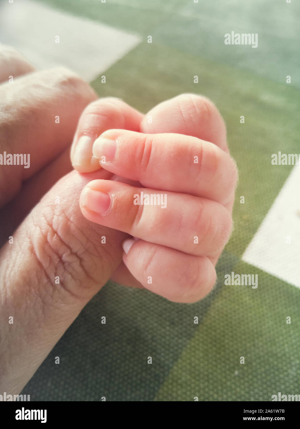 A baby's hand catching a man's finger Stock Photo - Alamy