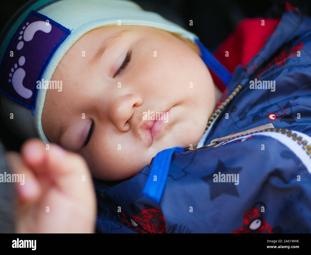 tired baby sleeping in a stroller. Cute adorable caucasian blond ...