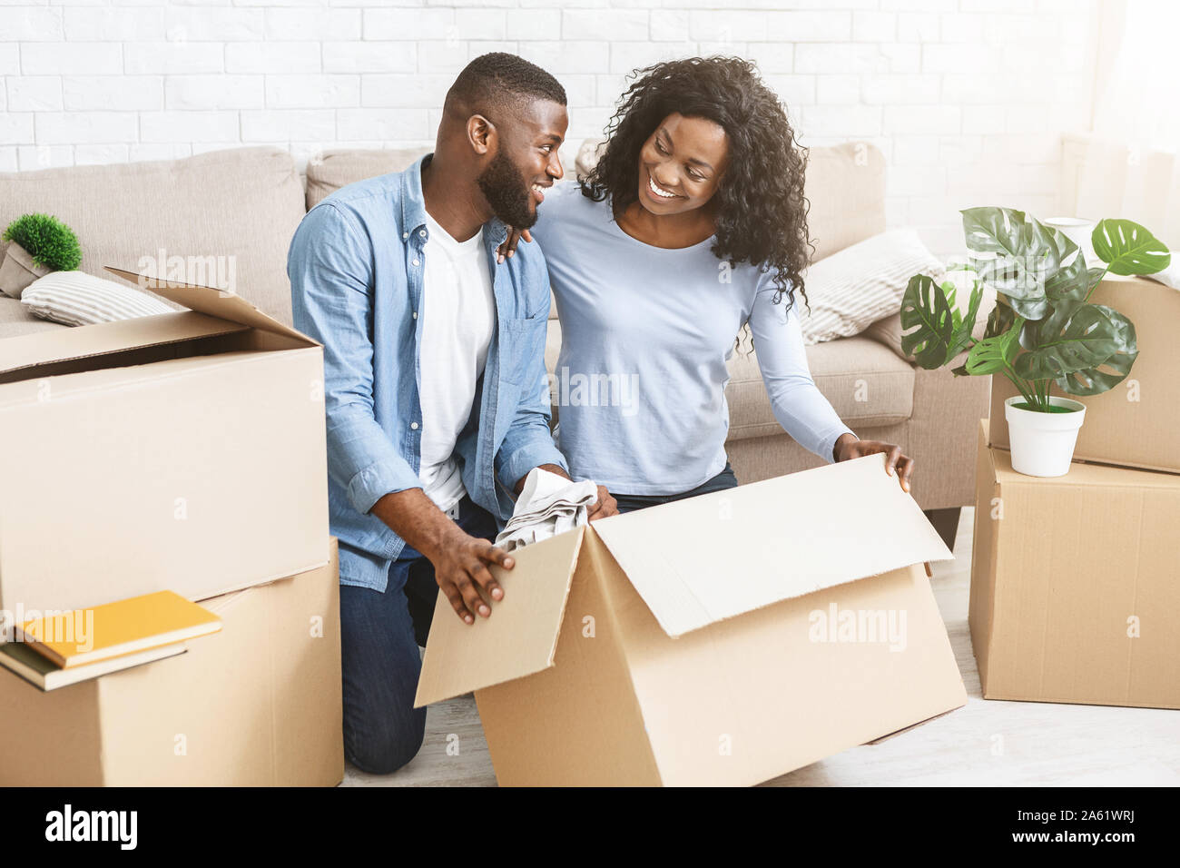 Excited black couple getting ready for moving out Stock Photo - Alamy
