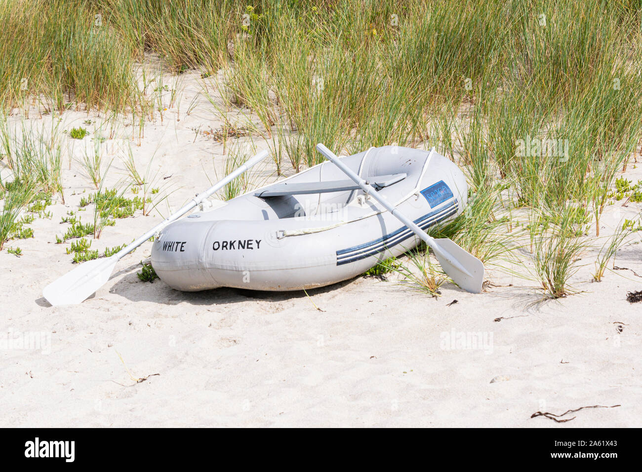An inflatable dinghy with oars pulled up on a beach Stock Photo - Alamy