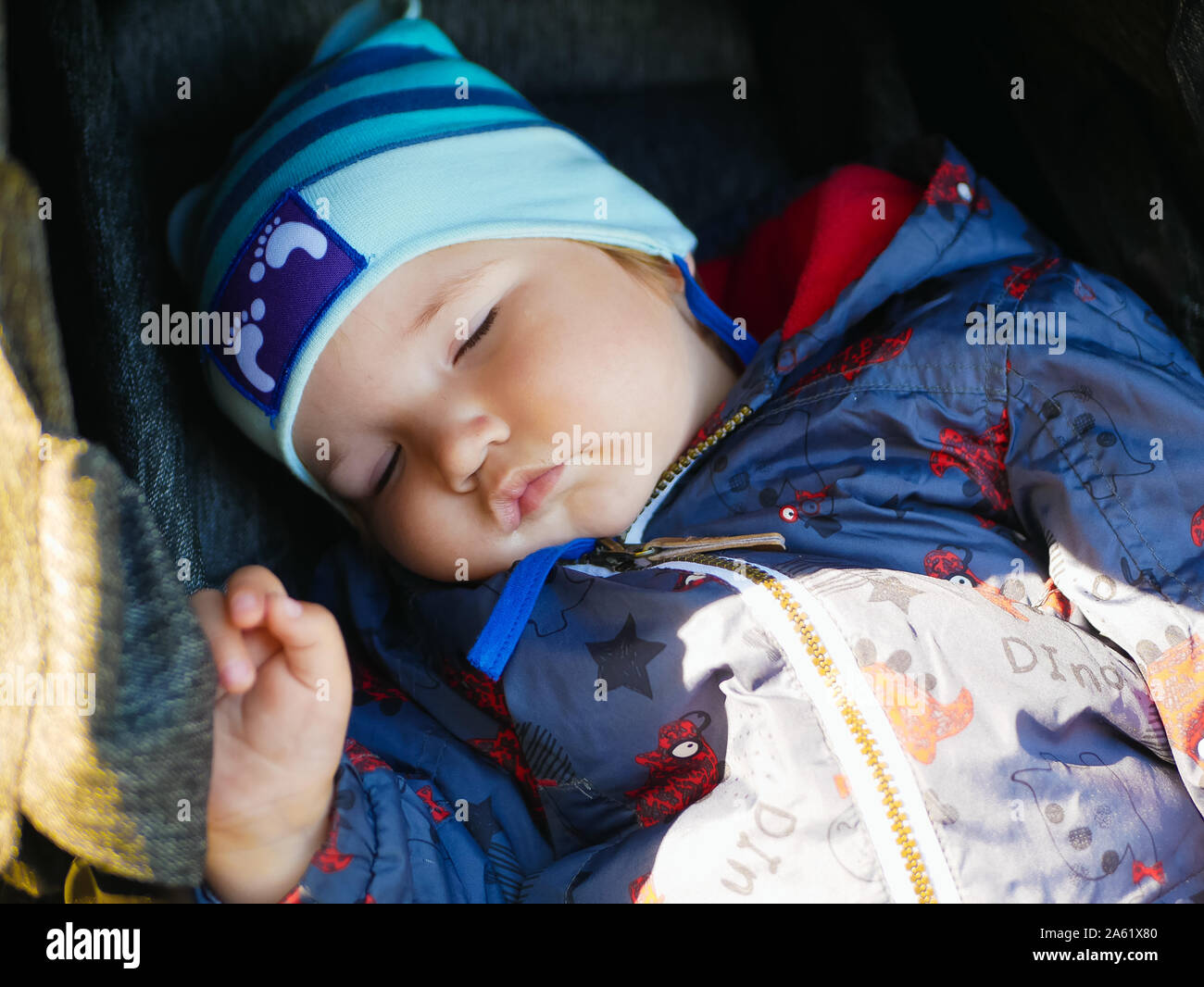 sleeping baby in a stroller for a walk. close-up. Cute little boy ...