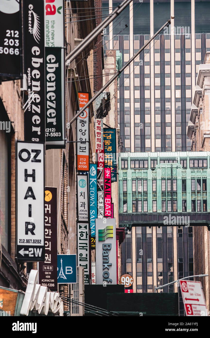 Multiple street signs crowding building side, NYC Stock Photo - Alamy
