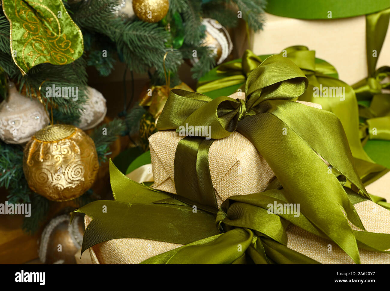 Close up green and beige paper wrapped gift boxes with ribbon bows ...