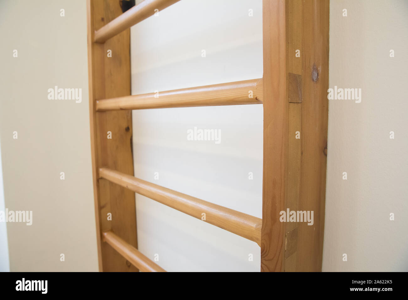 wooden wall bars ladder in big empty gym room of school . wooden back ...