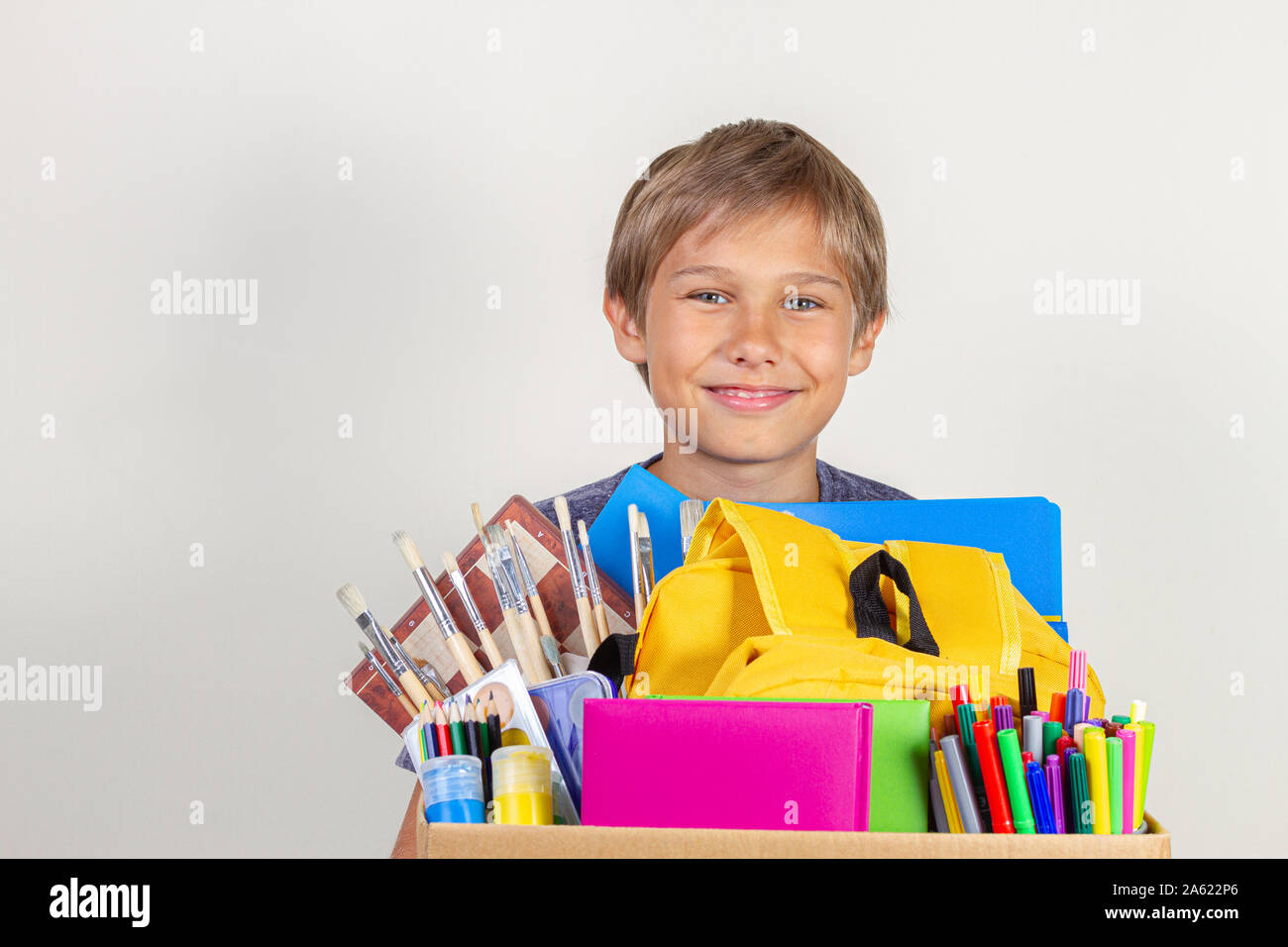 Donation concept. Kid holding donate box with books, pencils and school ...