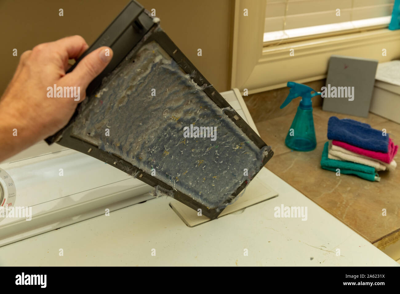 hand holding dirty lint trap while doing laundry Stock Photo - Alamy