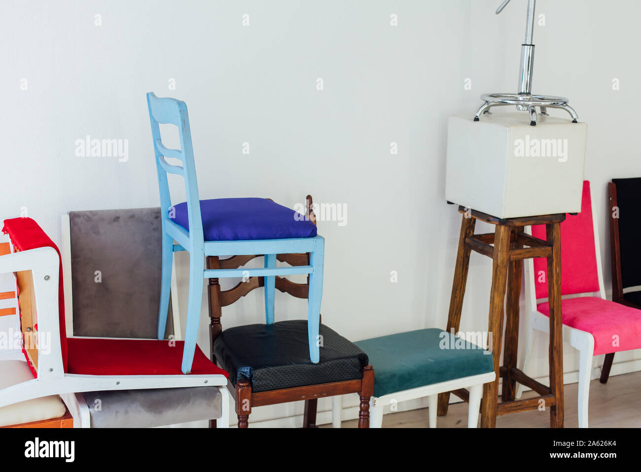 many multicolored chairs in the mess of the white room Stock Photo - Alamy