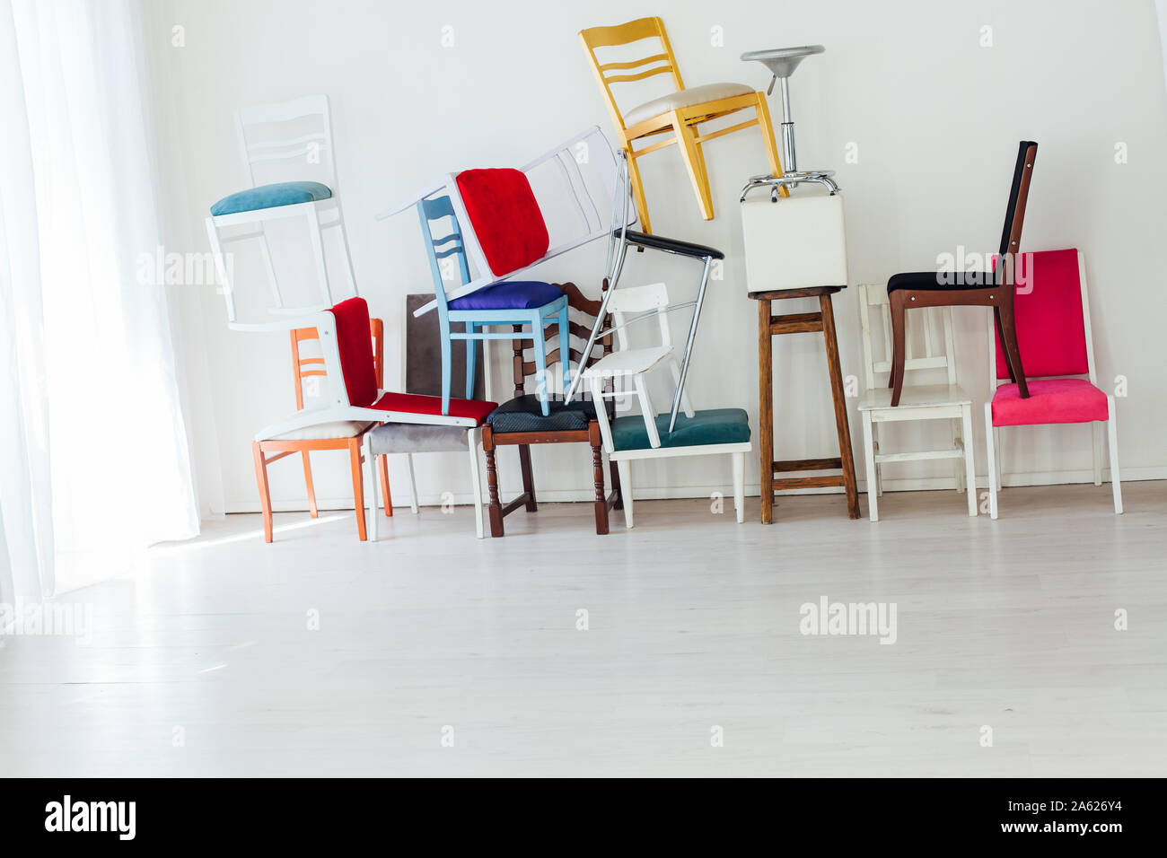 many multicolored chairs in the mess of the white room Stock Photo - Alamy