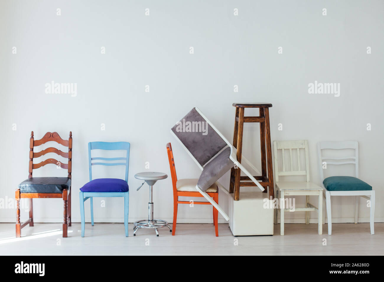 many multicolored chairs in the mess of the white room Stock Photo - Alamy