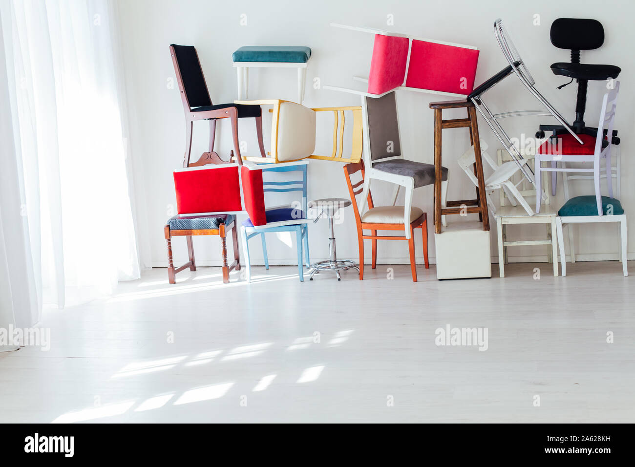 many multicolored chairs in the mess of the white room Stock Photo - Alamy