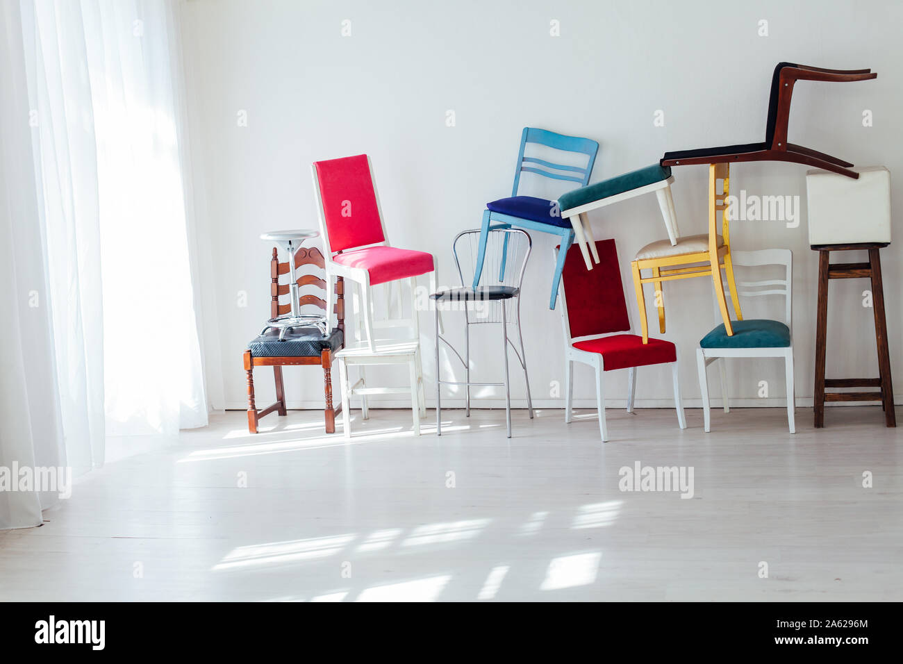 many multicolored chairs in the mess of the white room Stock Photo - Alamy