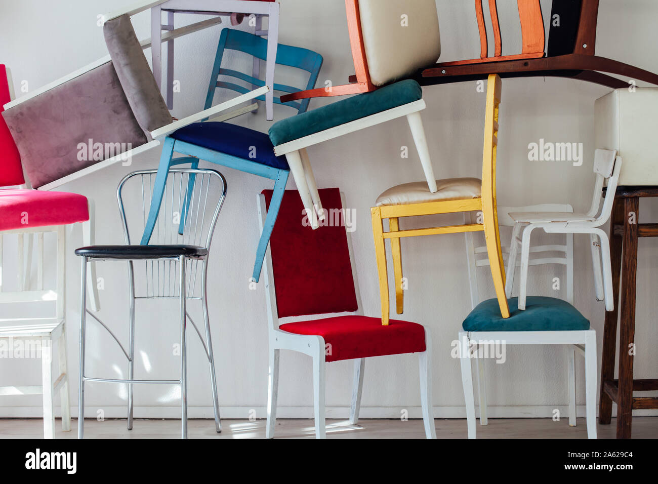 many multicolored chairs in the mess of the white room Stock Photo - Alamy