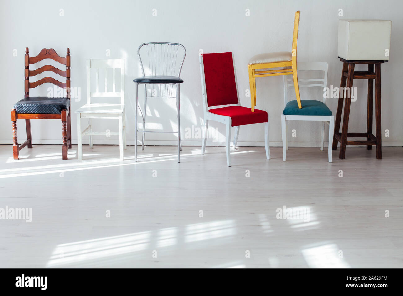 many multicolored chairs in the mess of the white room Stock Photo - Alamy
