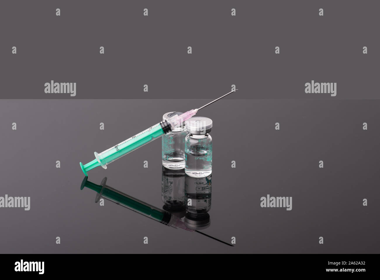 Syringe with a needle based on medical glass vials on a black ...