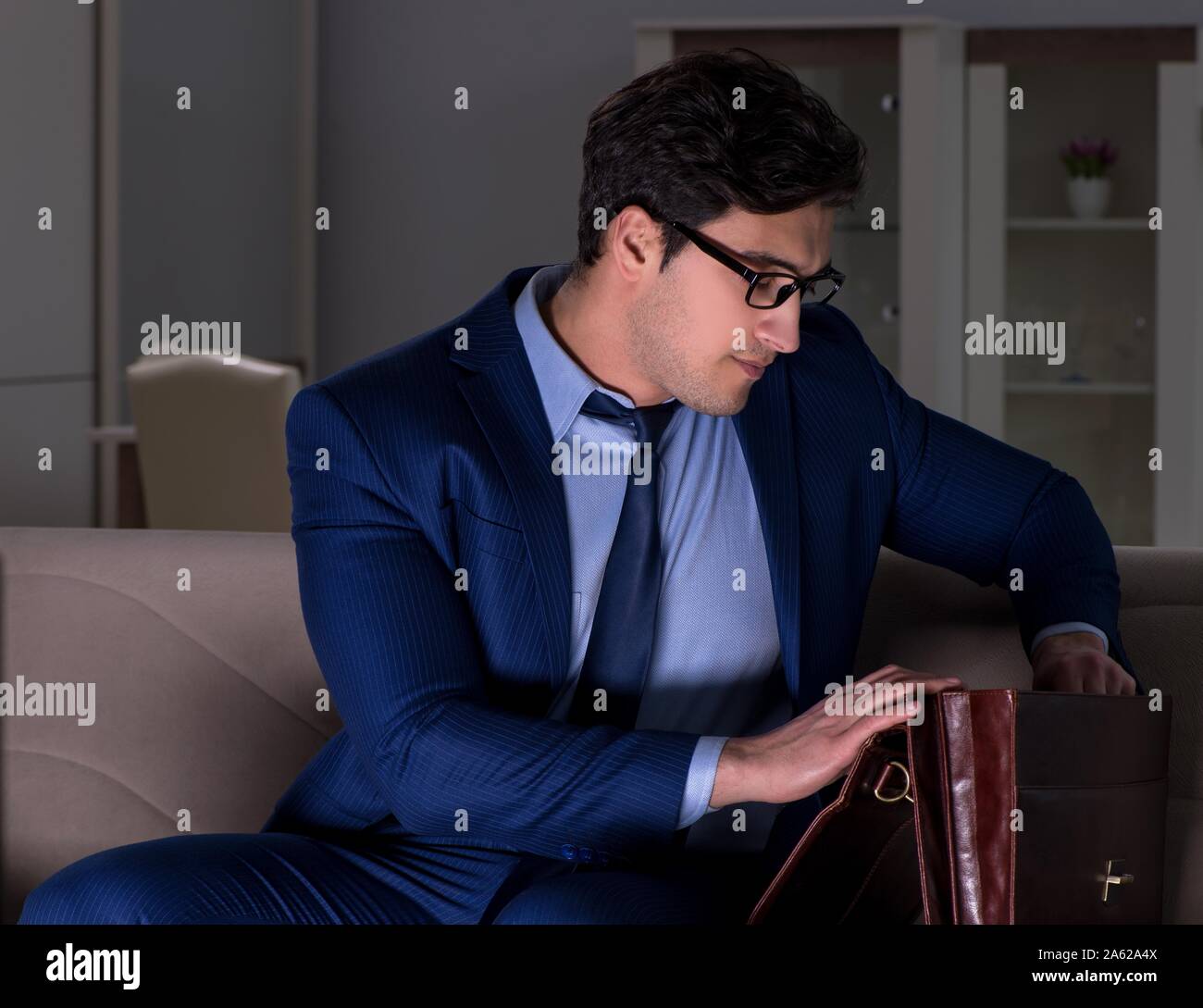 The businessman watching tv at night late Stock Photo - Alamy