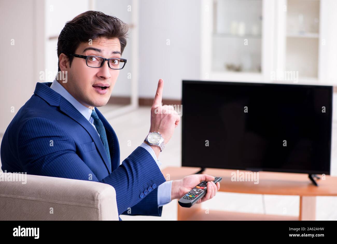 The businessman watching tv in the office Stock Photo - Alamy