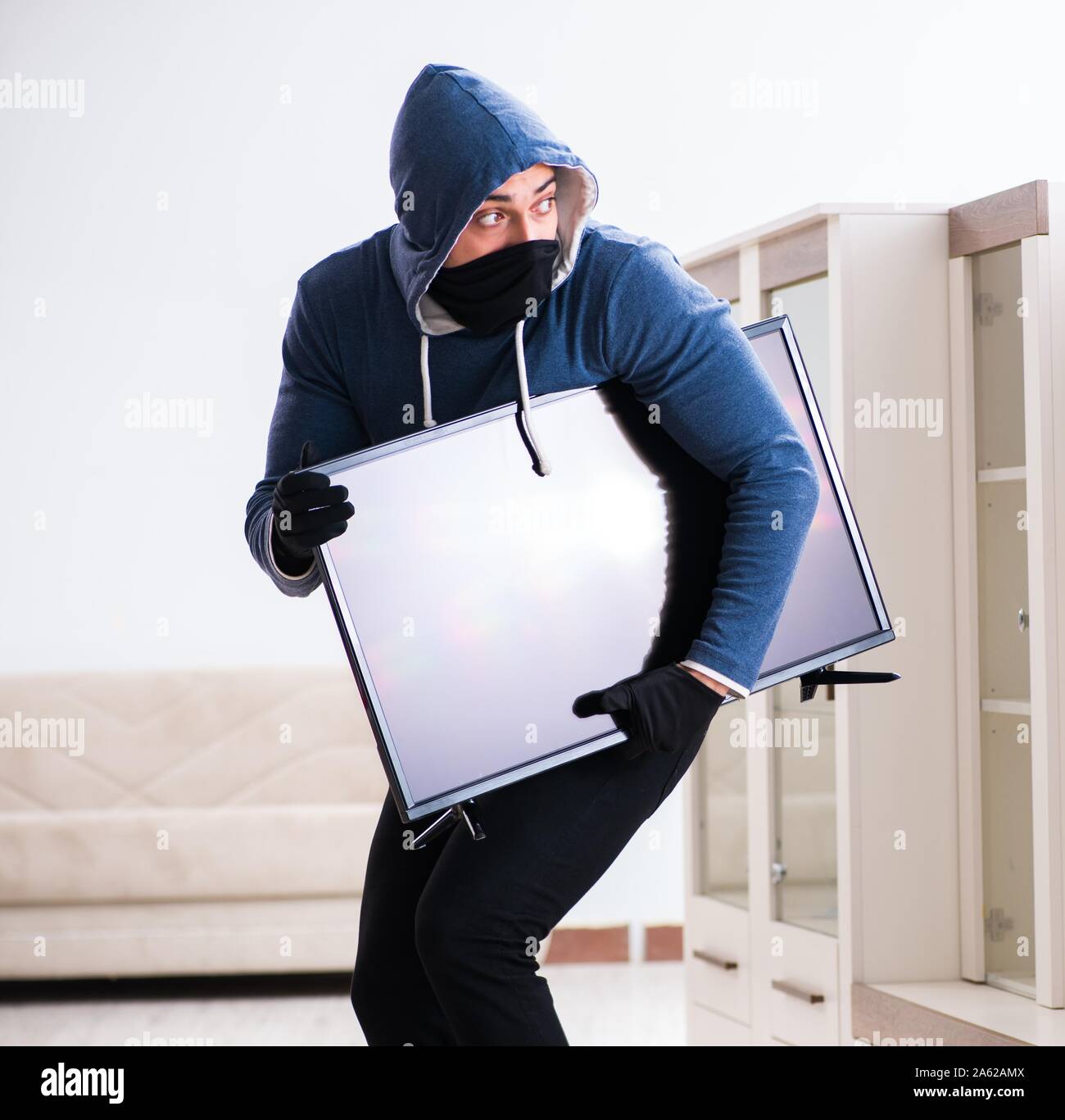 The man burglar stealing tv set from house Stock Photo - Alamy
