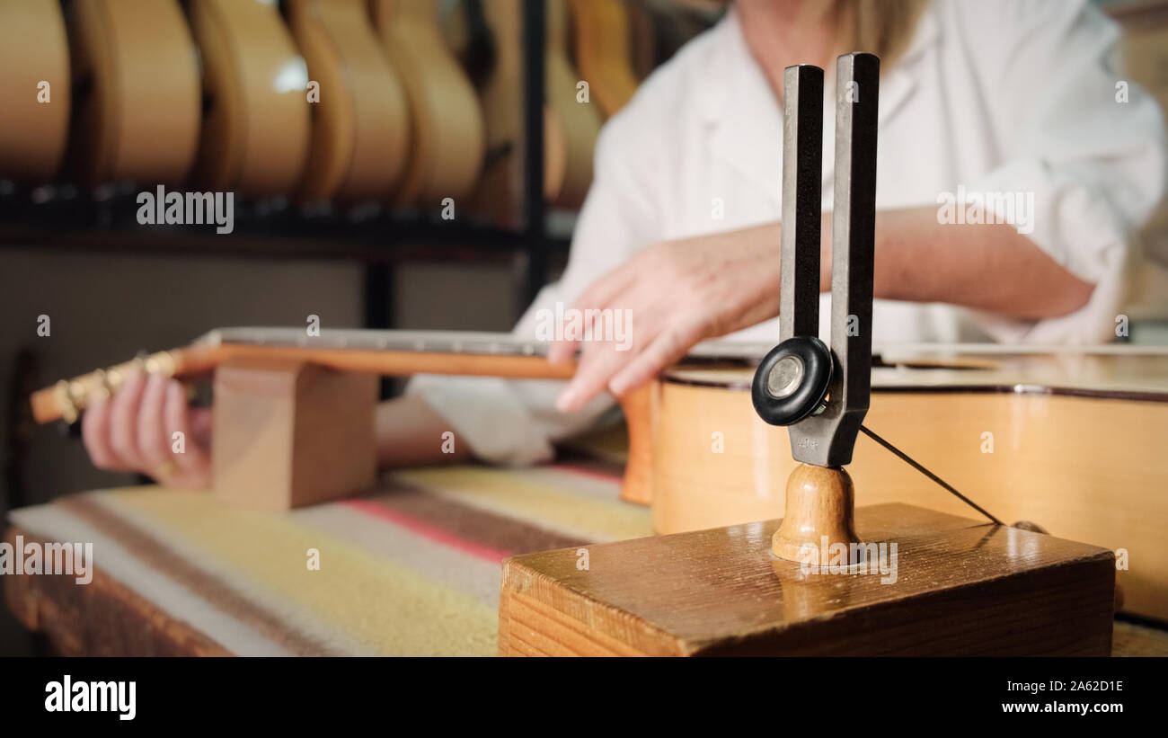 Woman Working As Lute Maker Tuning Guitar With Diapason Stock Photo - Alamy