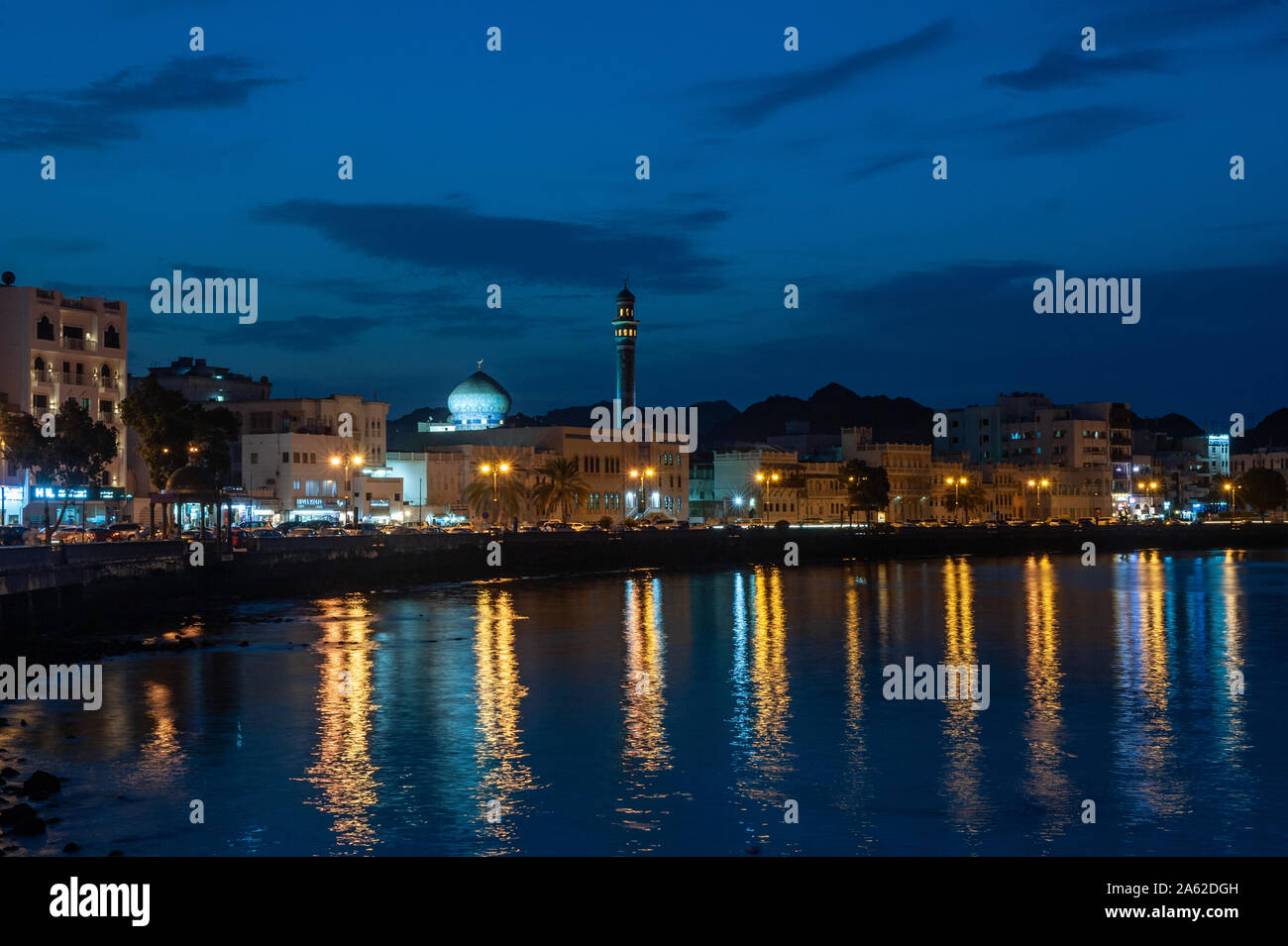 A mosque is lit up at night along the Corniche of Old Muscat, Oman ...