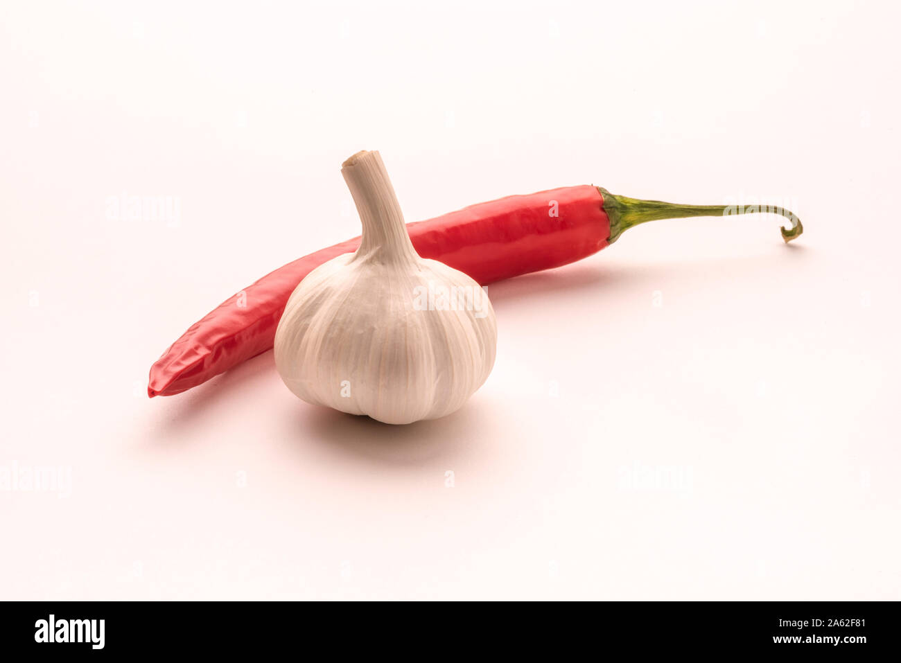 Red hot chili pepper and a raw garlic head isolated on a white ...