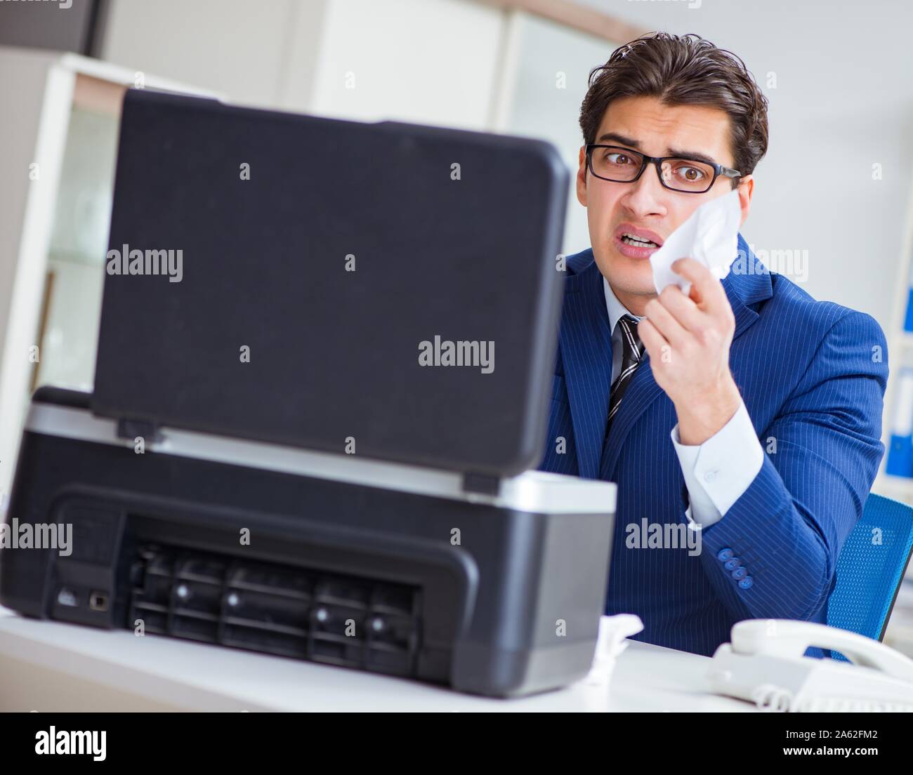 The businessman angry at copying machine jamming papers Stock Photo - Alamy
