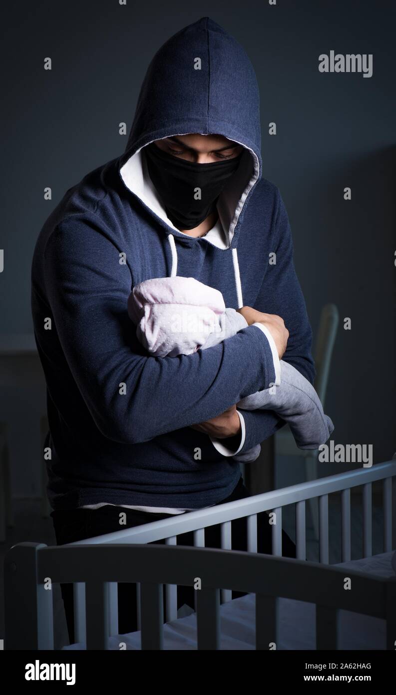 The criminal stealing baby in human child traficking concept Stock ...