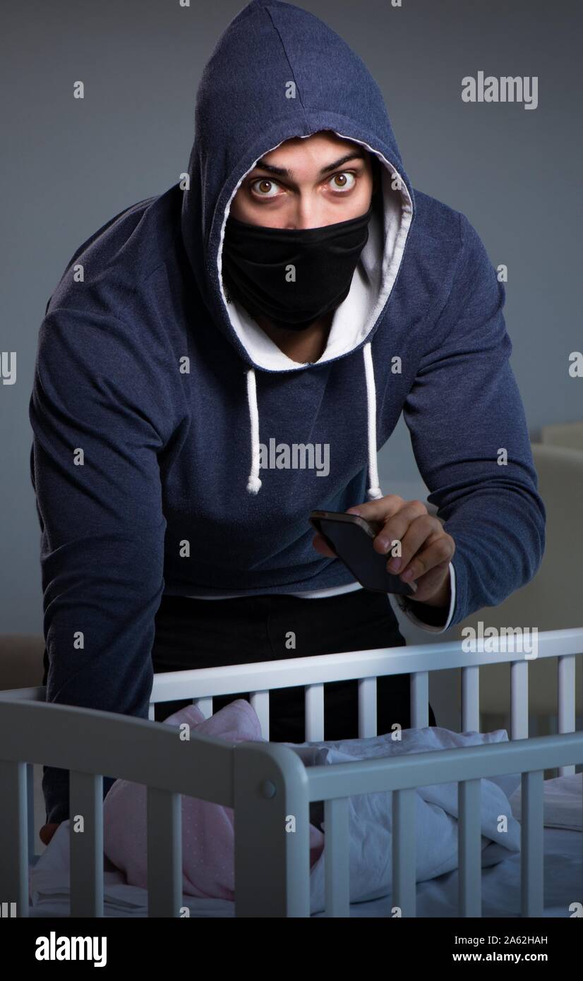 The criminal stealing baby in human child traficking concept Stock ...