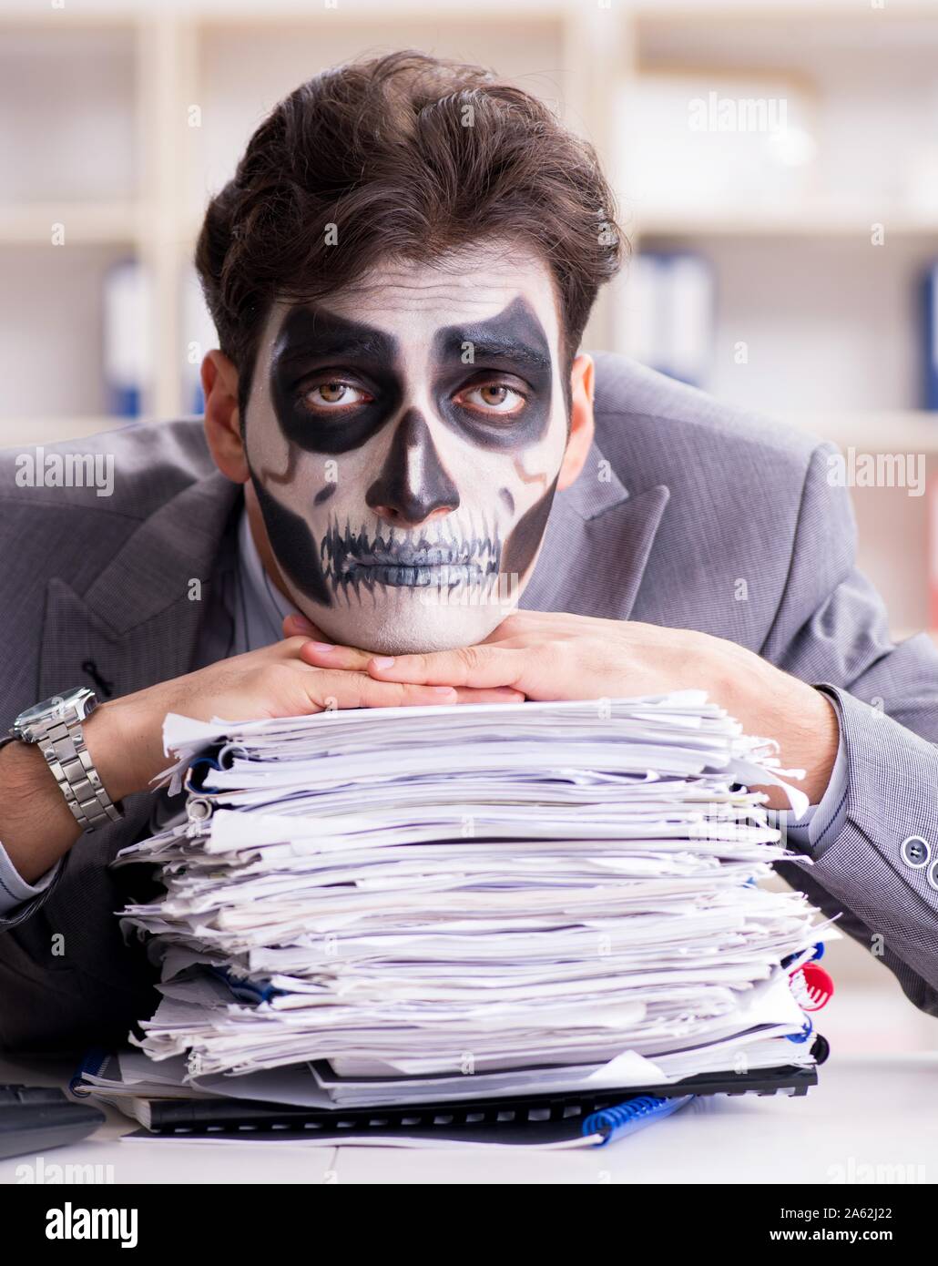 Businessman with scary face mask working in office Stock Photo - Alamy