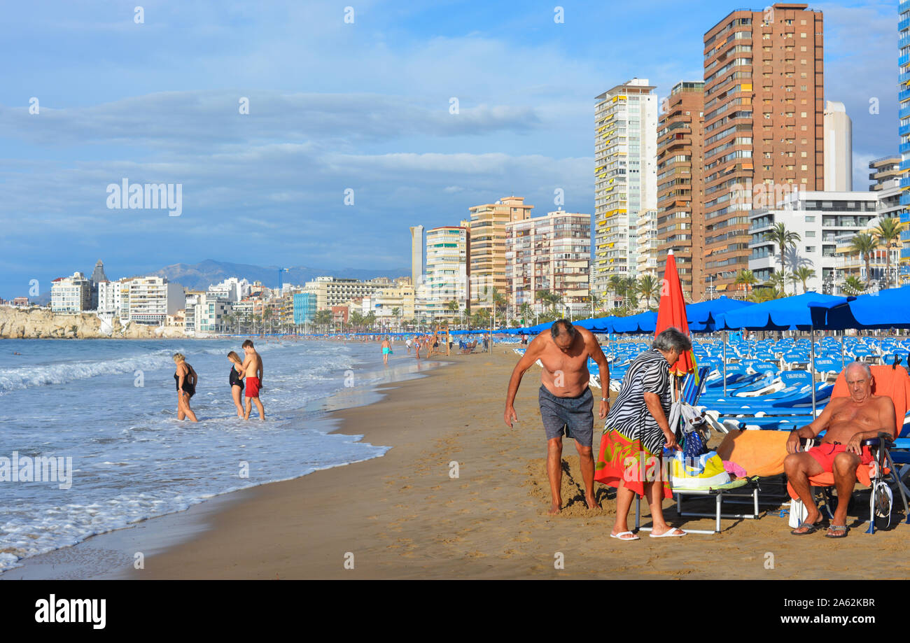 Group of active seniors on Playa Levante beach, with skyscrapers in the ...