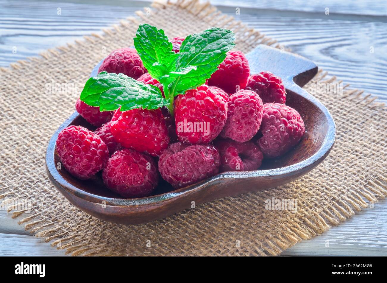 Fresh red fruits. Juicy raspberries in a wooden dish Stock Photo - Alamy