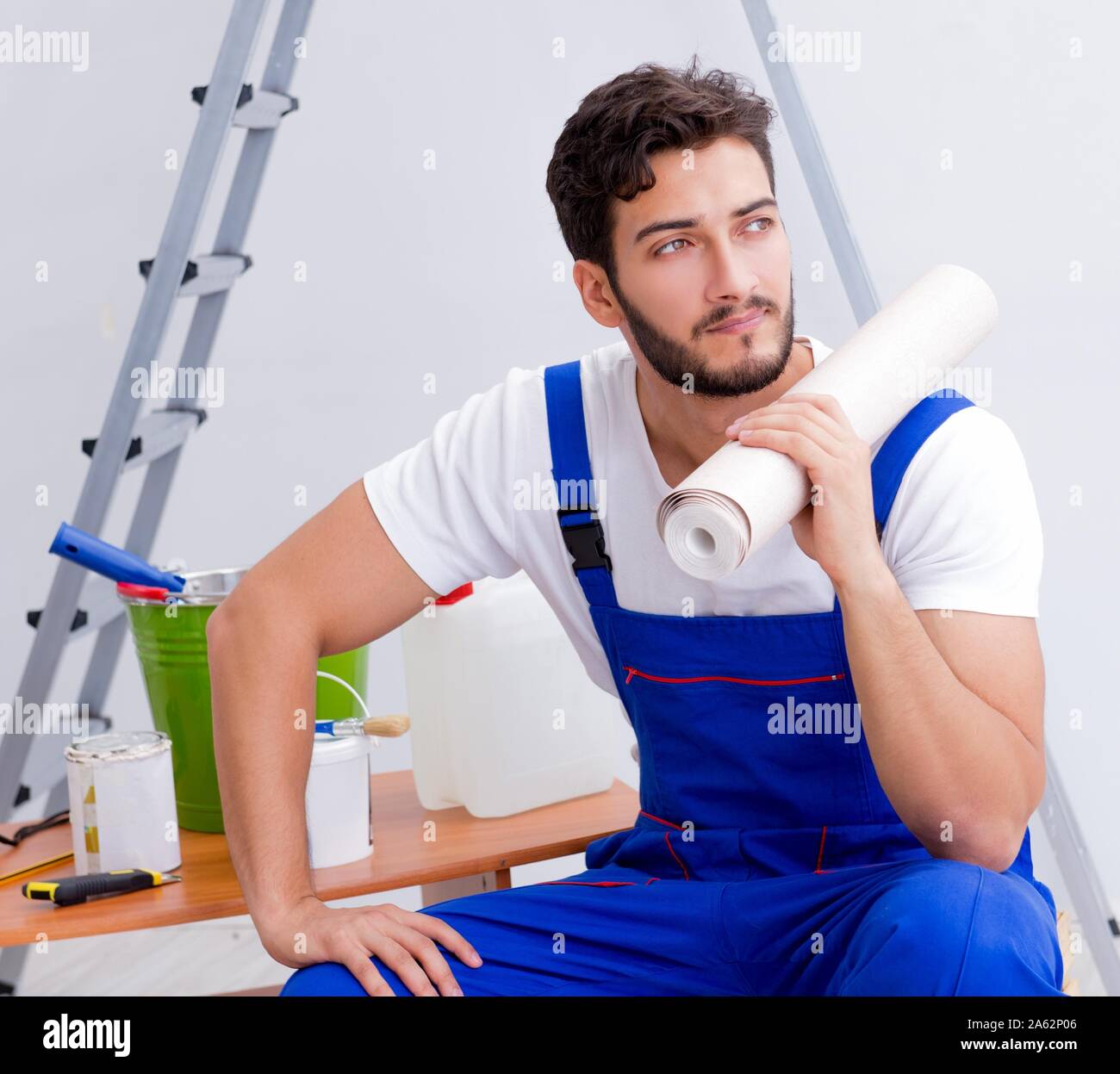 Repairman doing renovation repair in the house with paper wallpaper ...