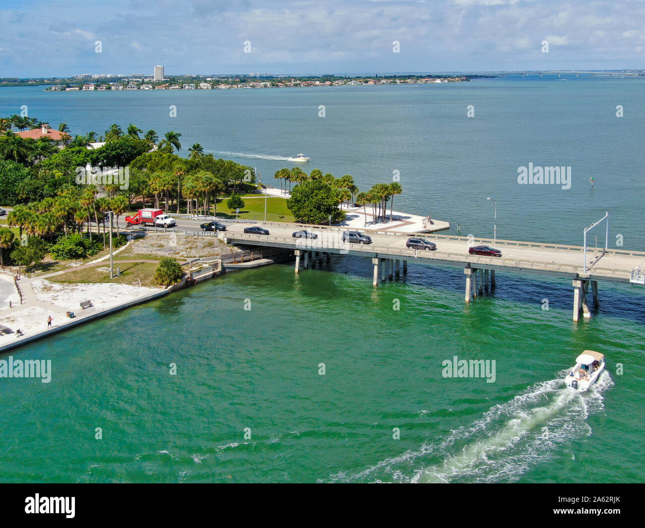 Aerial view of open street bridge crossing ocean with small boat and ...