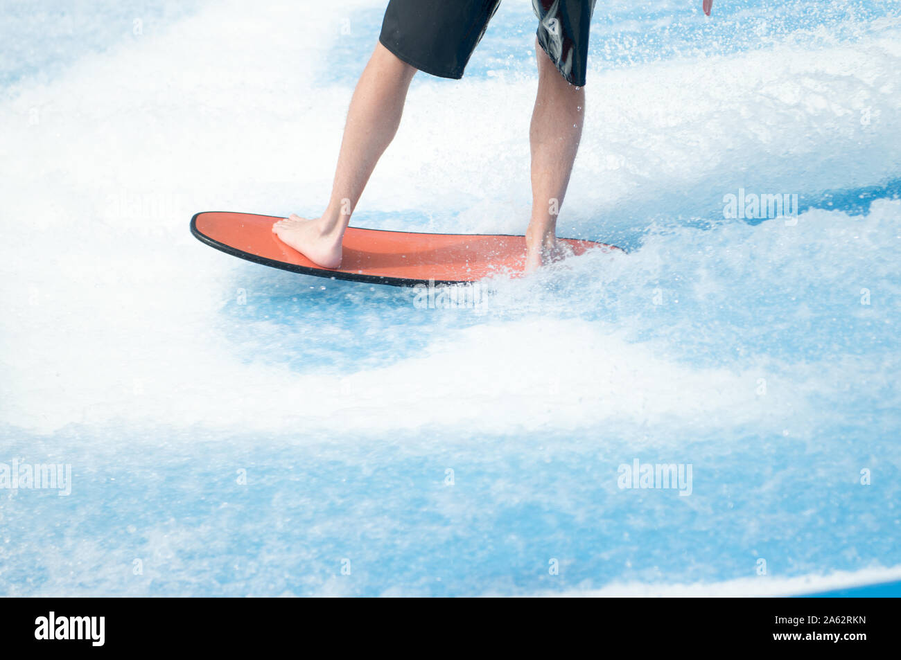 White waves rush past a surfer on a surf board Stock Photo - Alamy