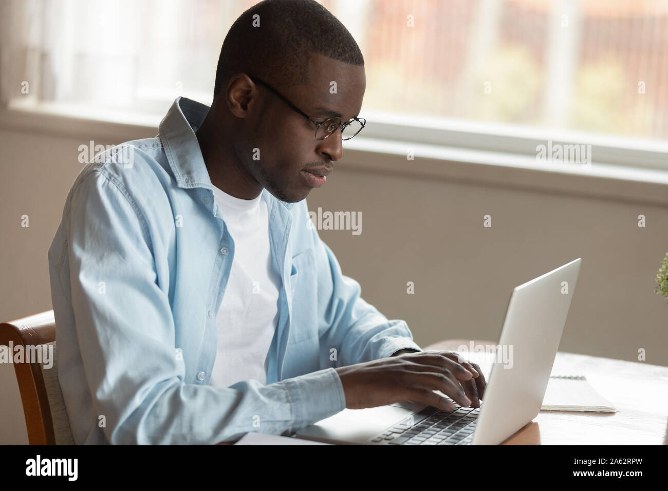 Serious concentrated young african american man working remotely with ...