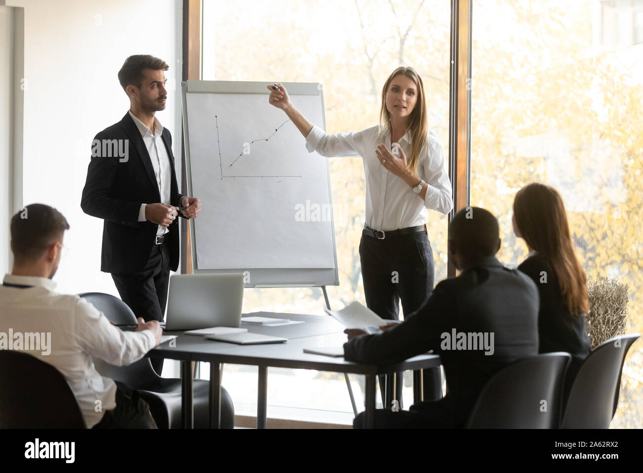 Professional business speakers team give flip chart presentation at ...