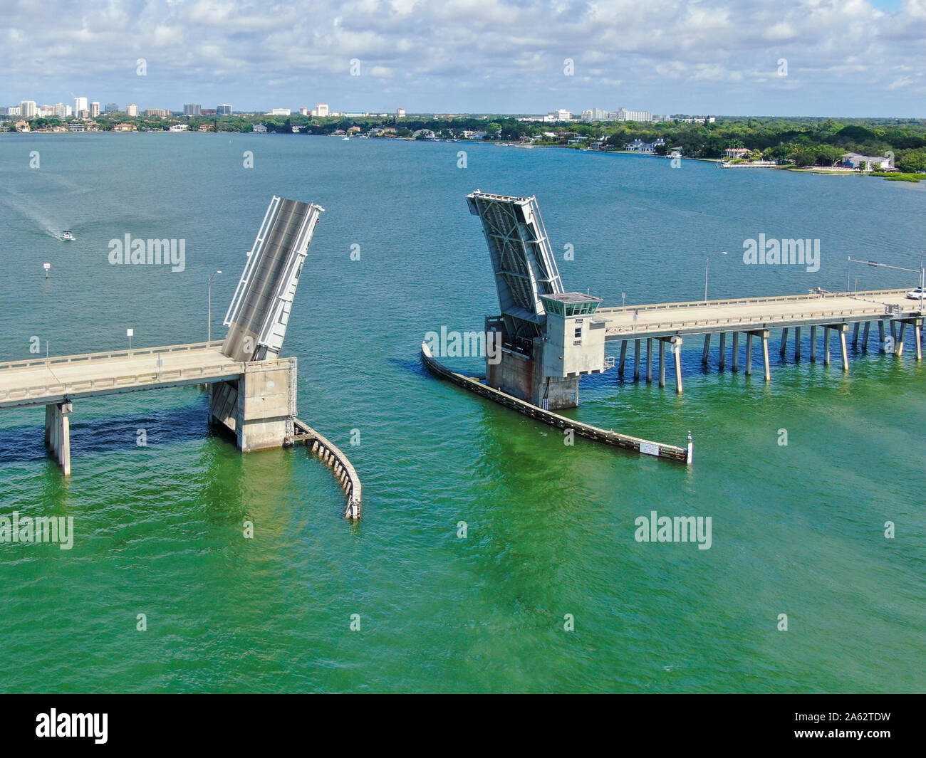Aerial view of open street bridge crossing ocean with small boat and ...
