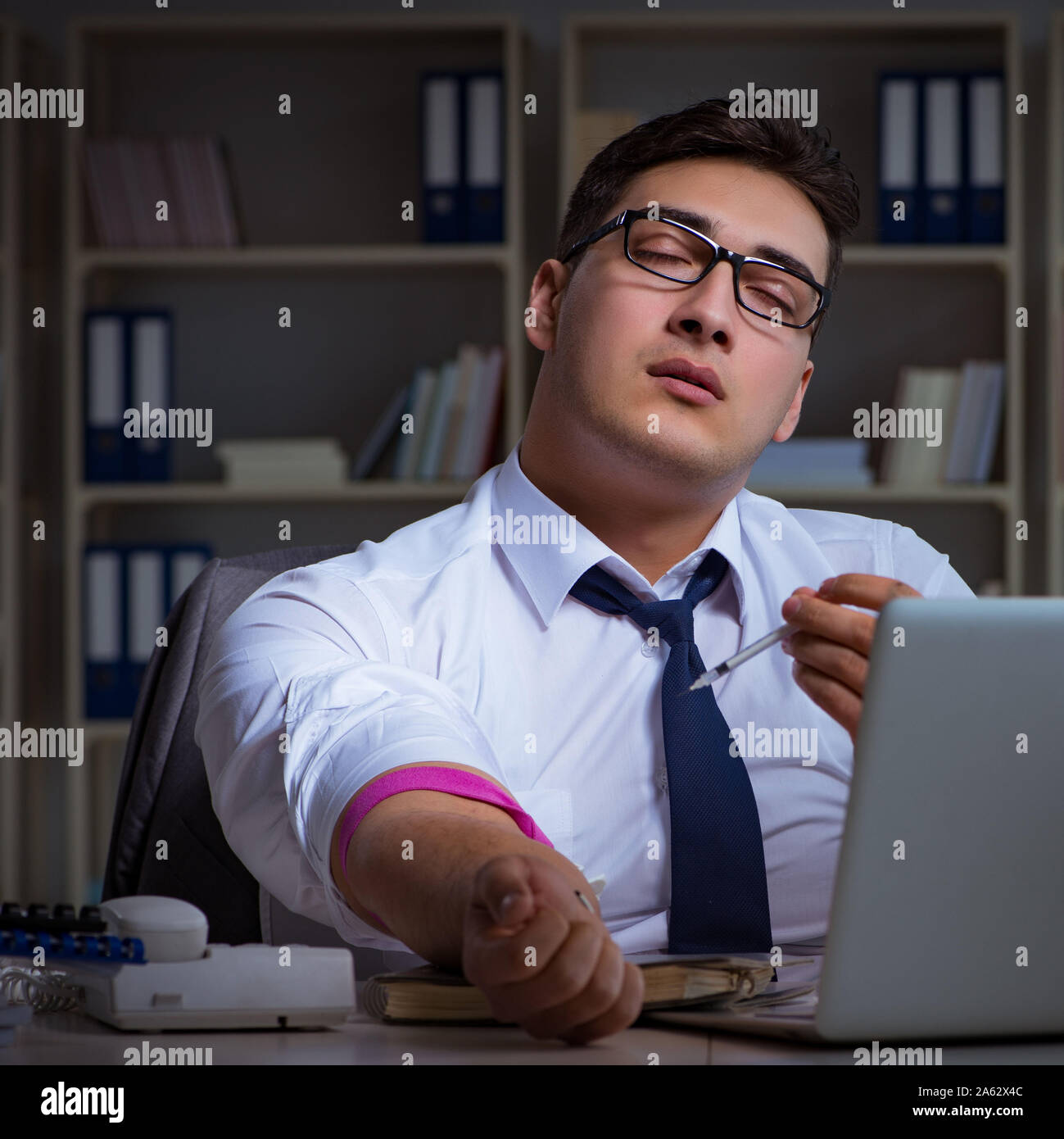 The businessman staying late in office for drugs Stock Photo - Alamy