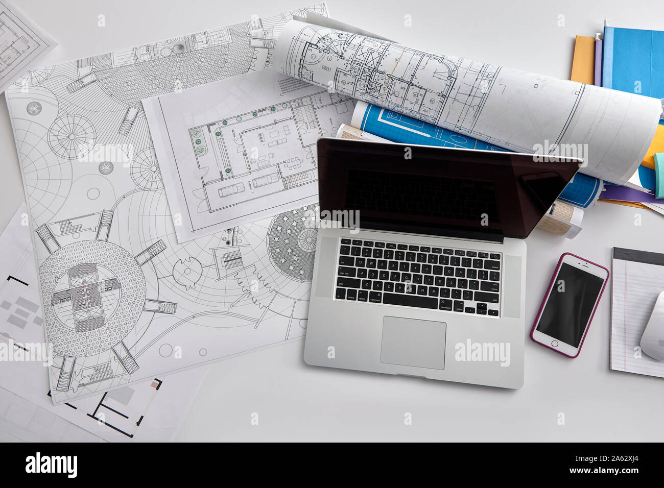 Office desk set up, with laptops, architectural blueprints and ...