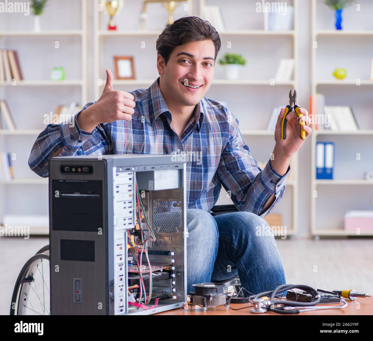The disabled man on wheelchair repairing computer Stock Photo - Alamy