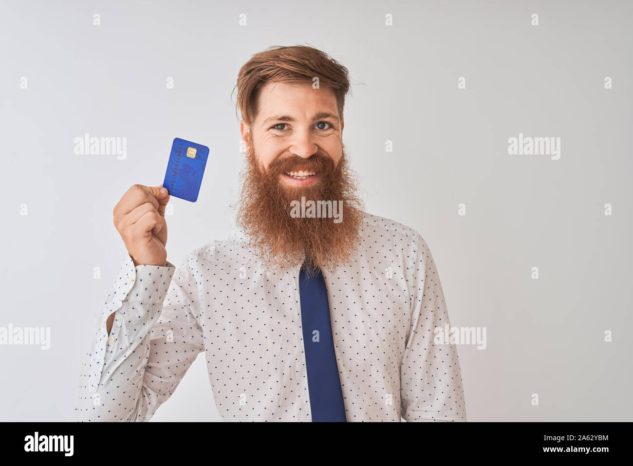 Young redhead irish businessman holding credit card standing over ...