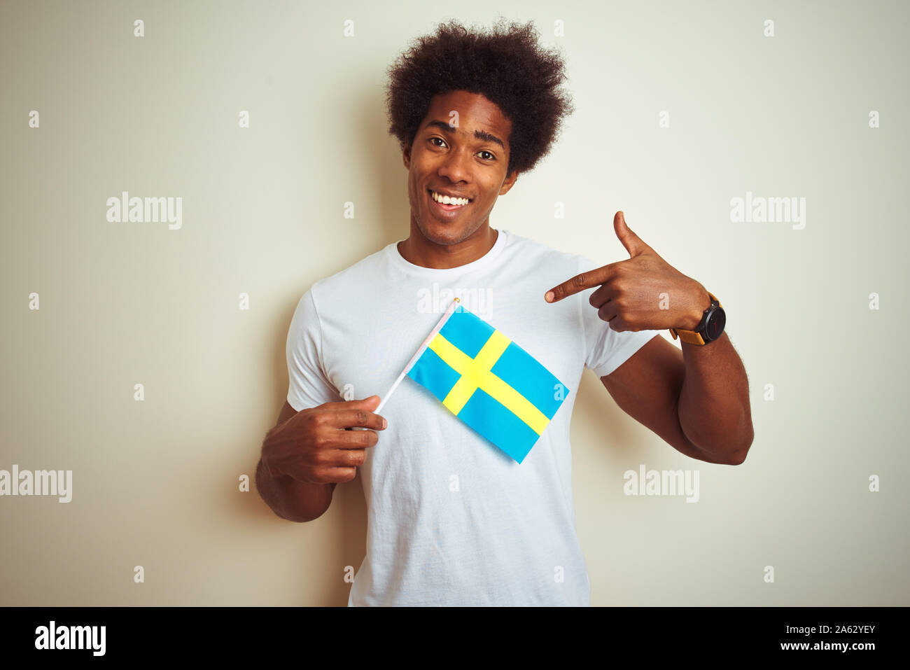 Young afro american man holding Sweden Swedish flag standing over ...
