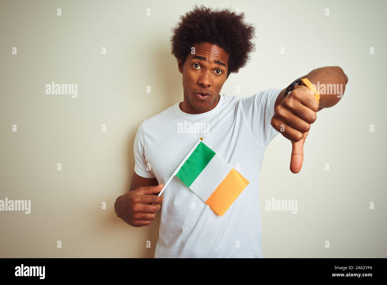 Young african american man holding Ireland Irish flag standing over ...
