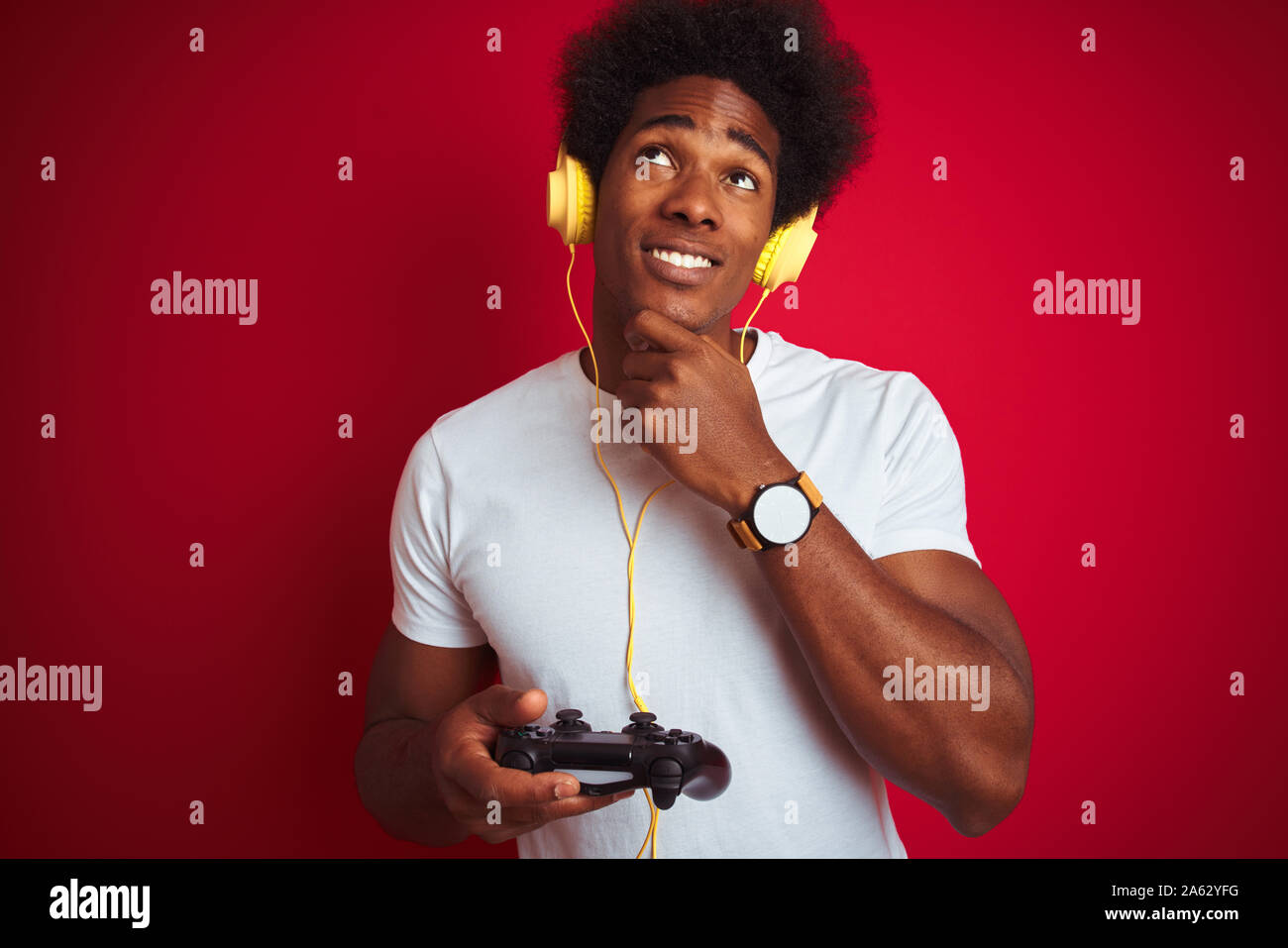Afro gamer man playing video game using joystick headphones over ...