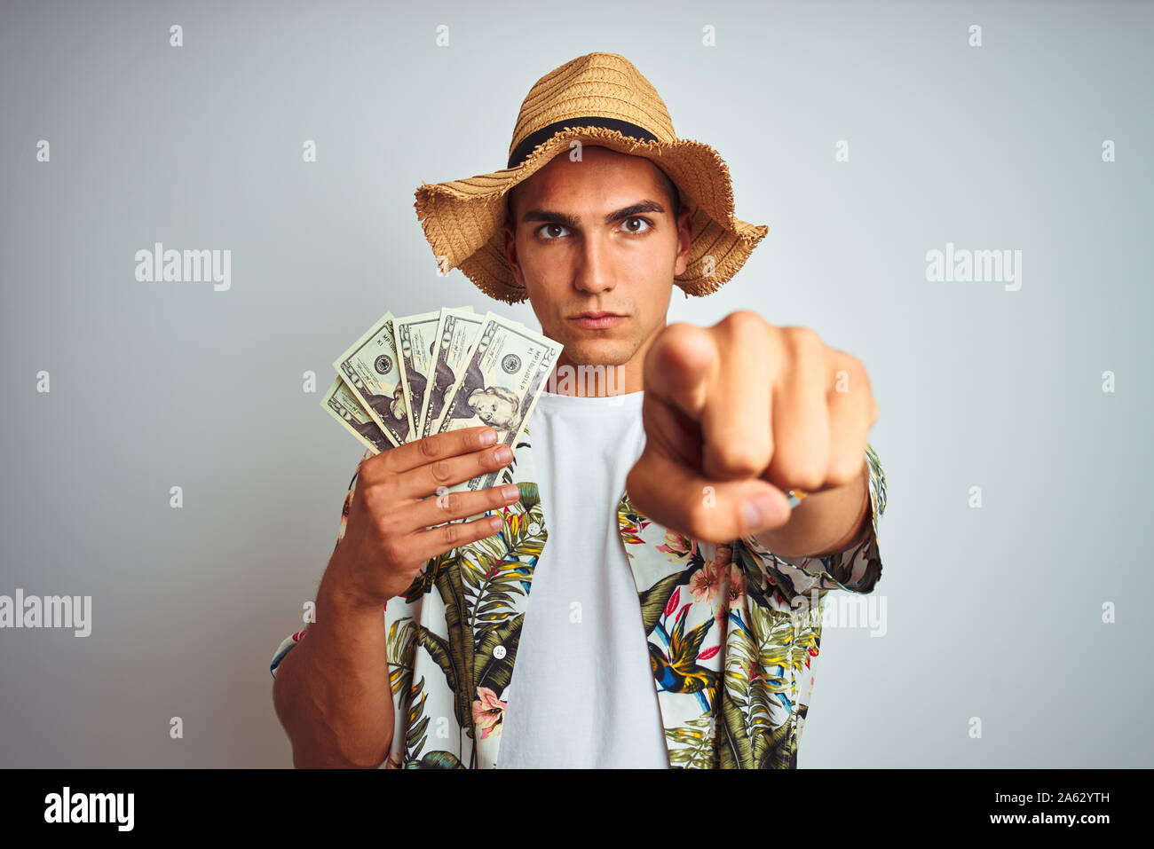 Young man on holidays holding dollars bank notes over white isolated ...
