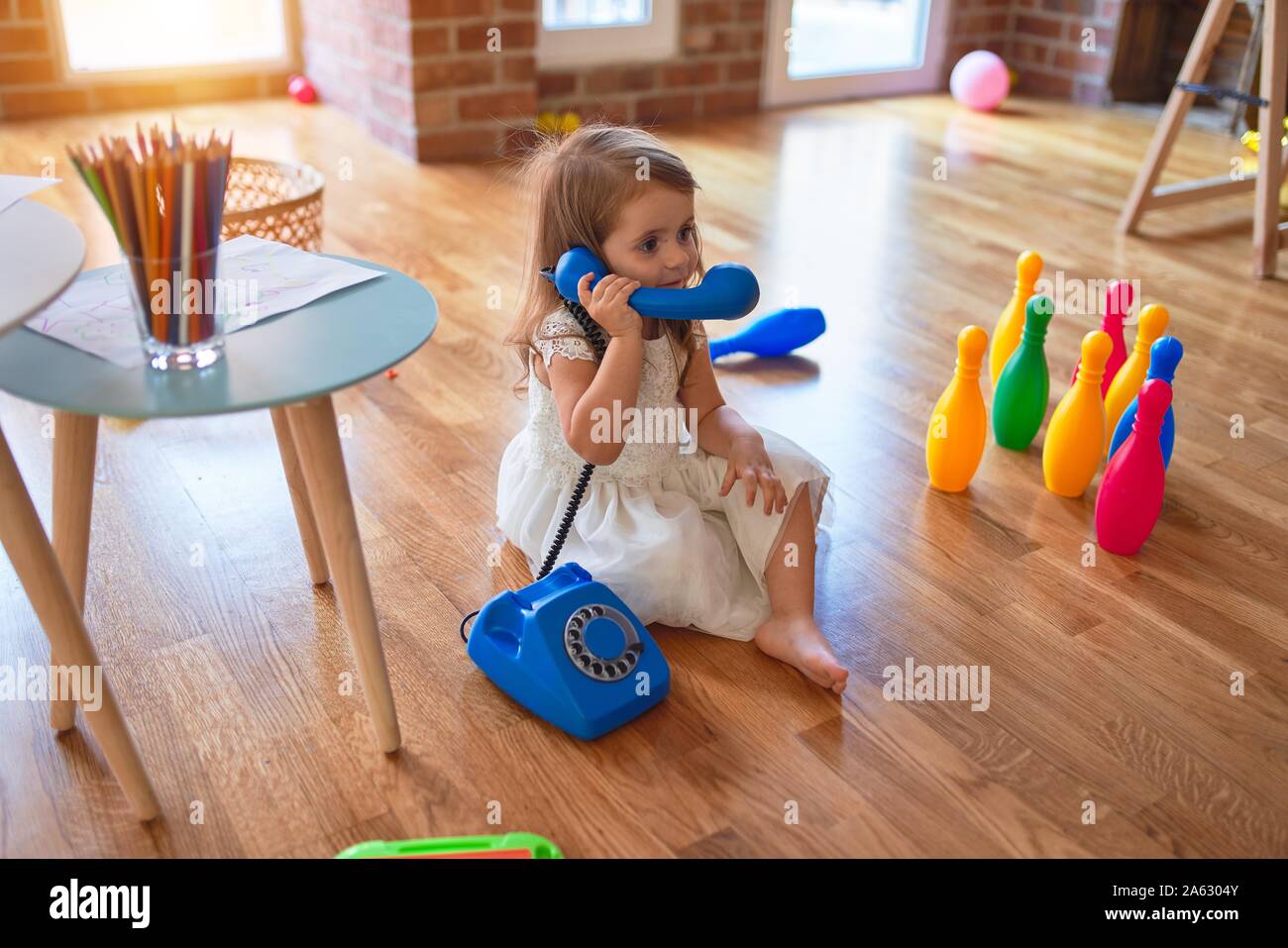 Adorable blonde toddler playing with vintage telephone. Sitting on the ...