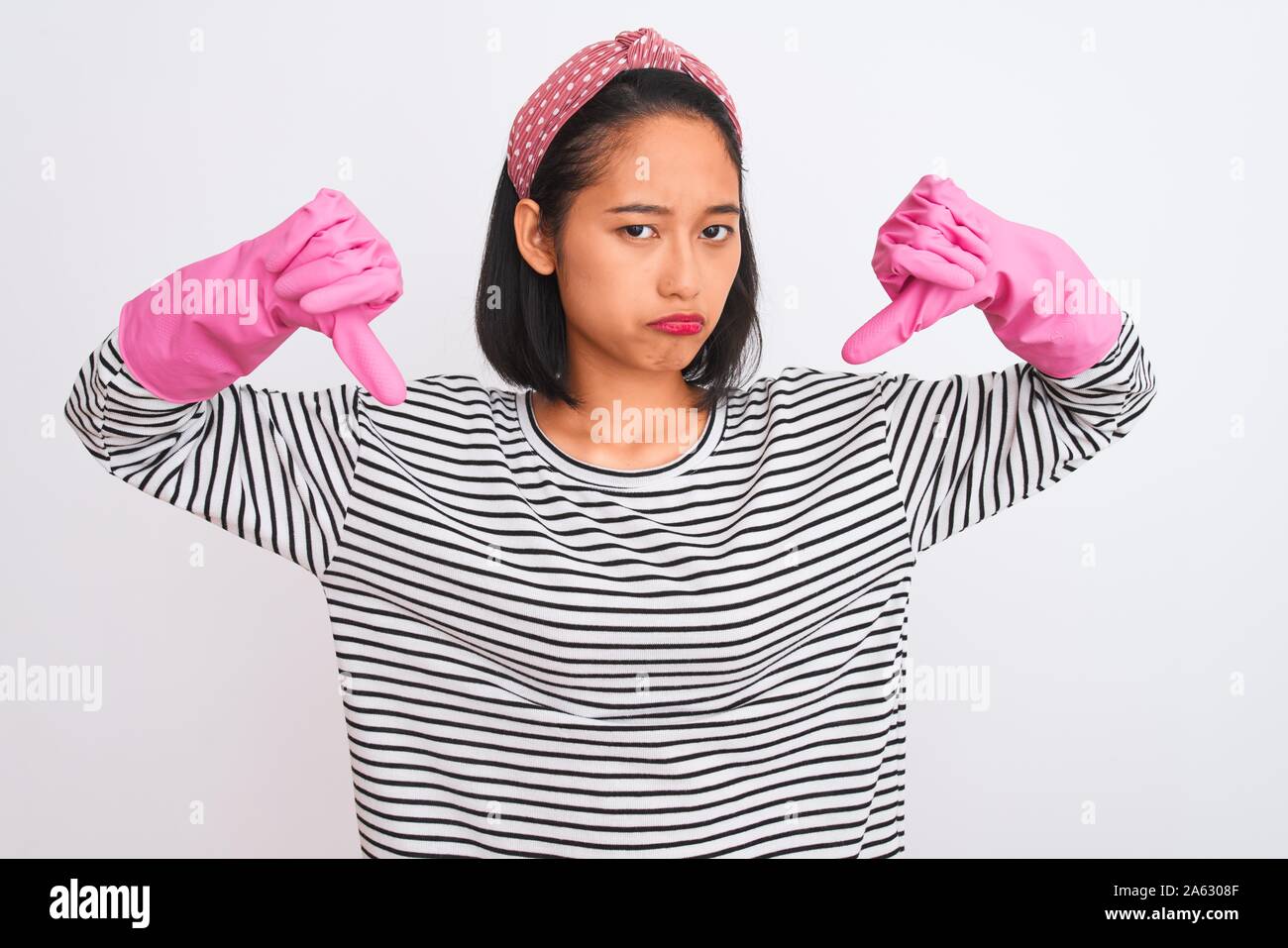 Young chinese cleaner woman cleaning using gloves over isolated white ...