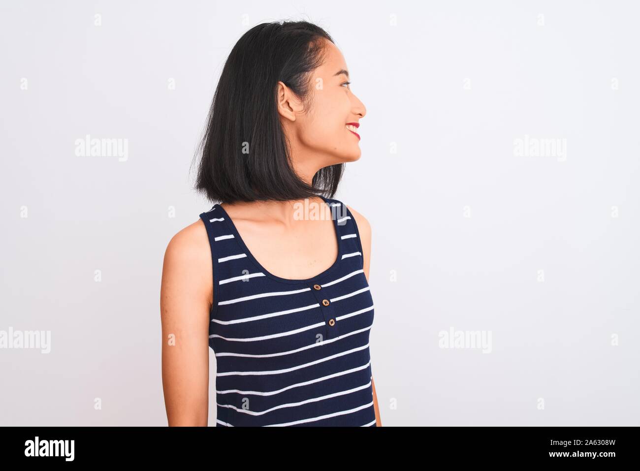 Young chinese woman wearing striped t-shirt standing over isolated ...
