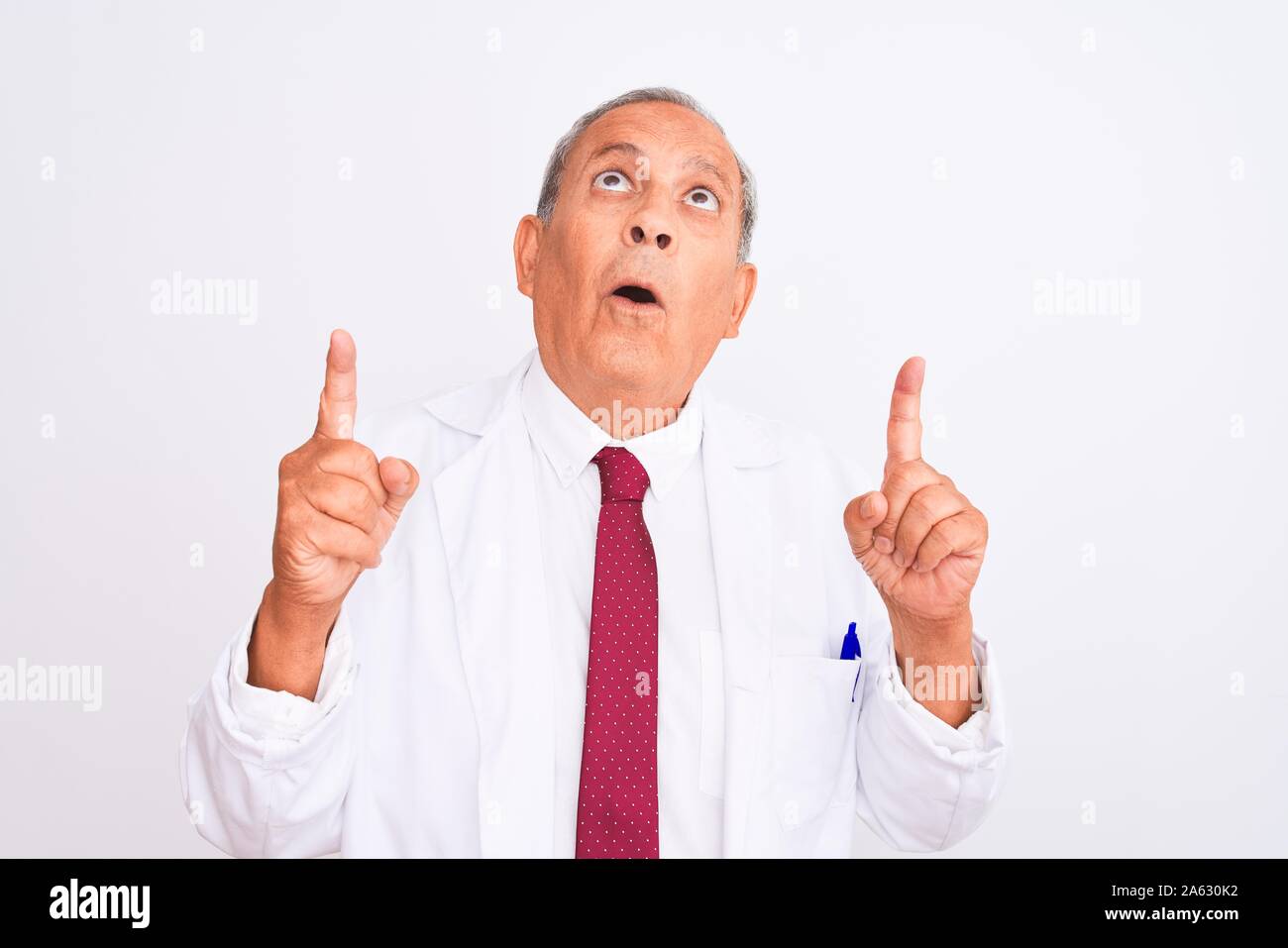 Senior grey-haired scientist man wearing coat standing over isolated ...